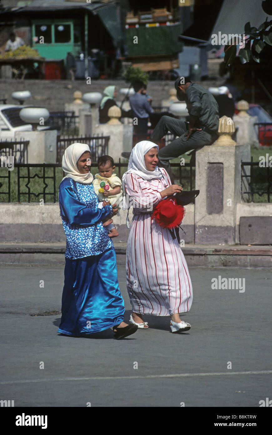 Two Egyptian women in hijabs carrying a baby while walking through Khan ...