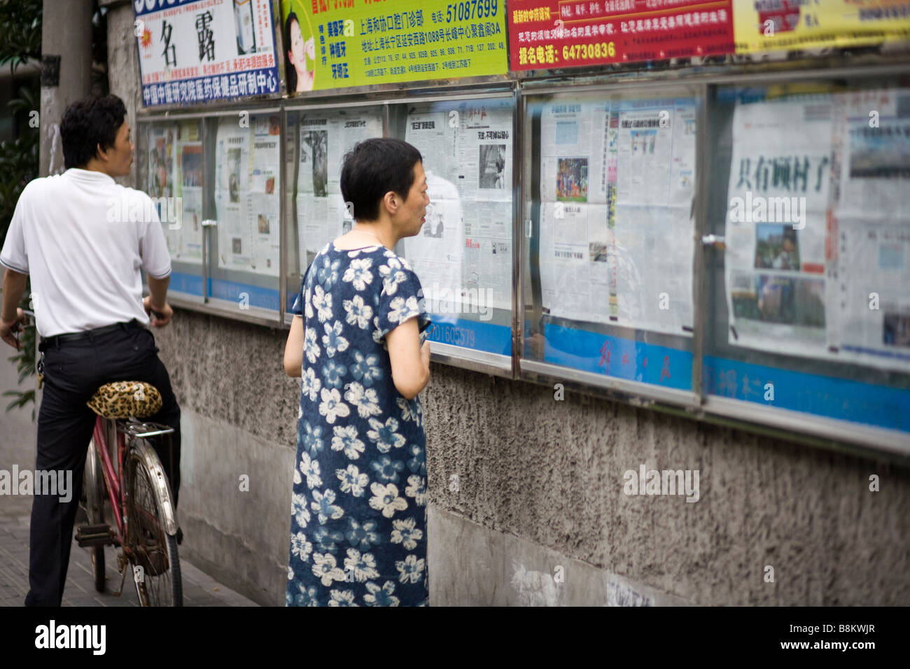 Shanghaiese reading the news on an outdoor newspaper display board ...