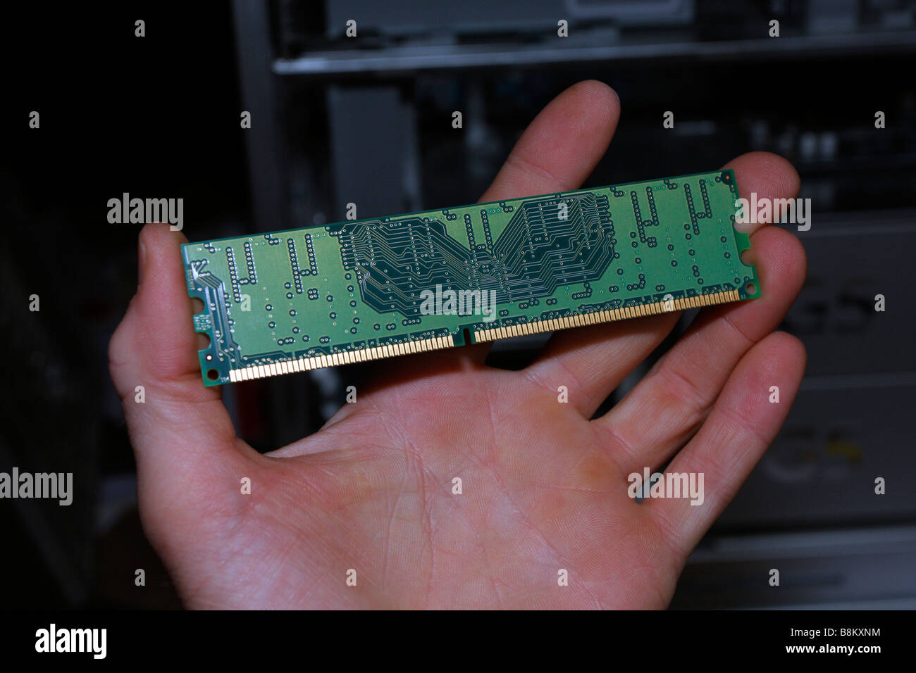 Male hand holding one stick of RAM, 1x256MB SDRAM PC3200U, back side ...