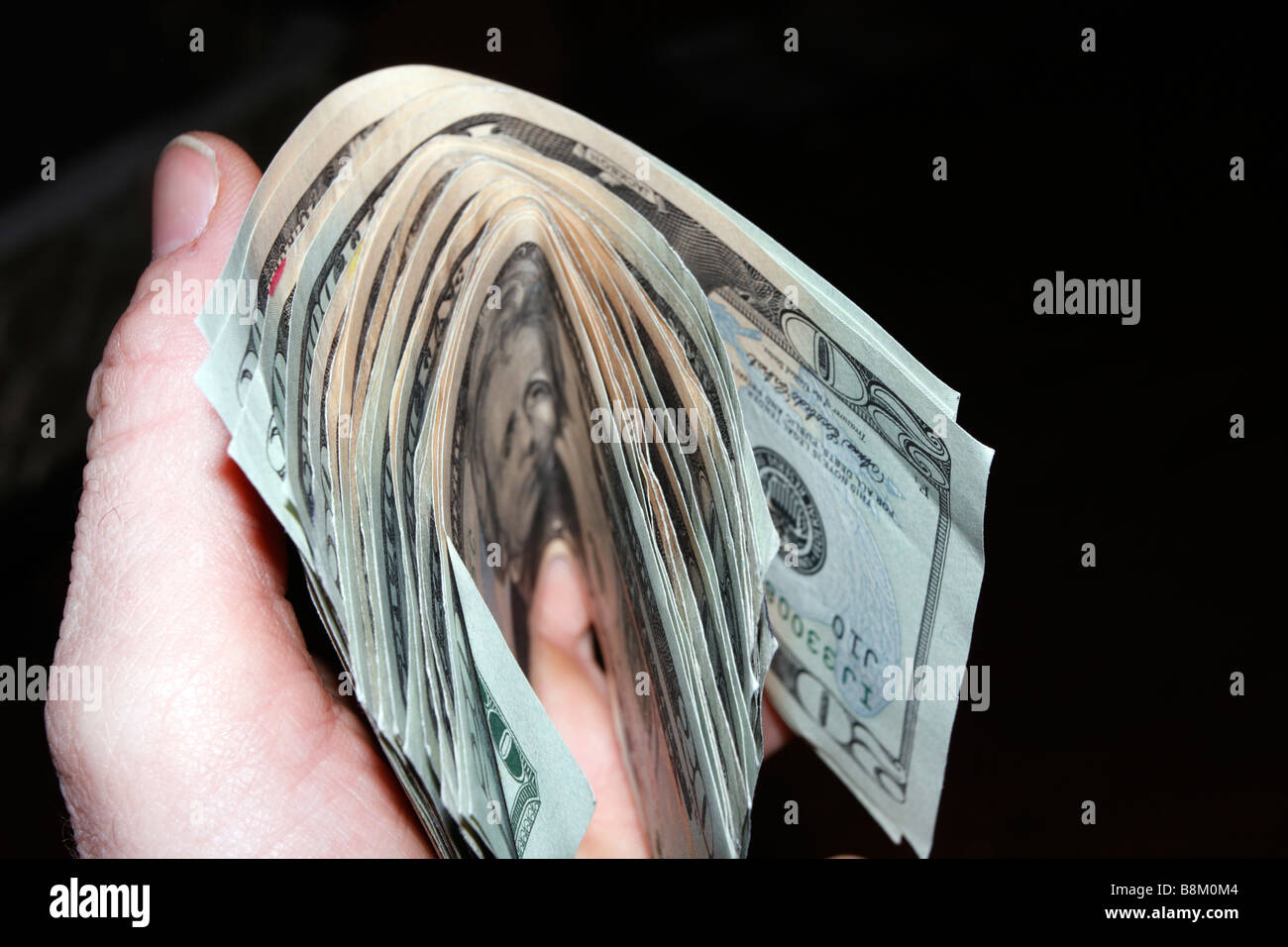 Loose handful of folded USA $20 twenty dollar bills. On black Stock ...