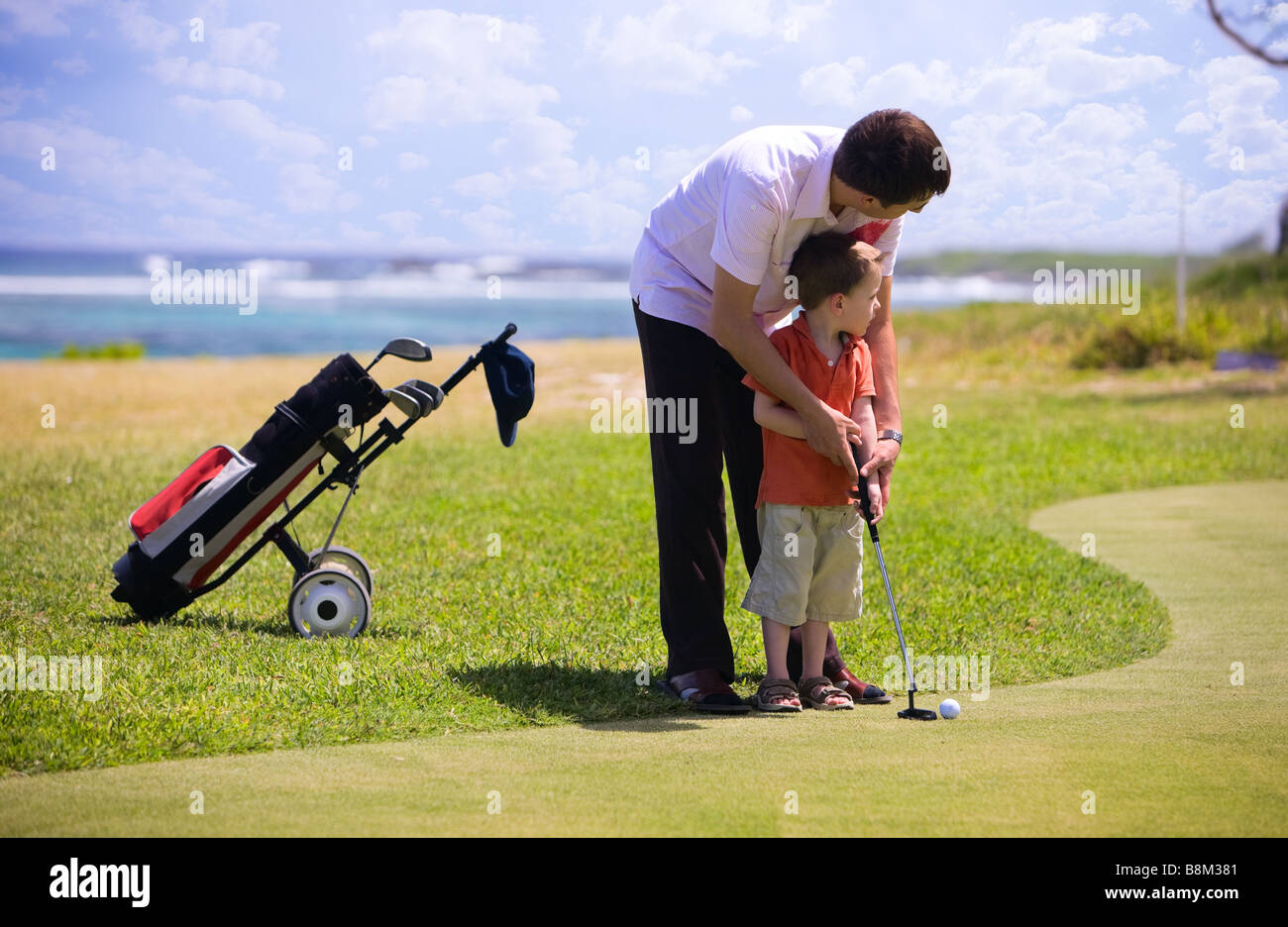 Father teaching his son how to play golf Stock Photo - Alamy