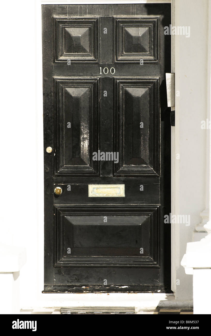 Black door numbered No 100 Stock Photo - Alamy