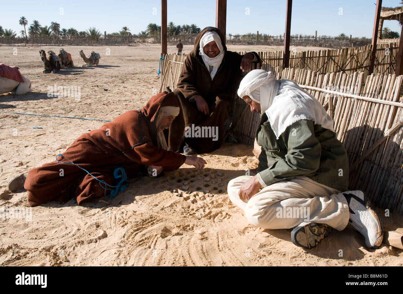 Waiting for tourists in Douz, Tunisia, Berber camel owners play a chess ...