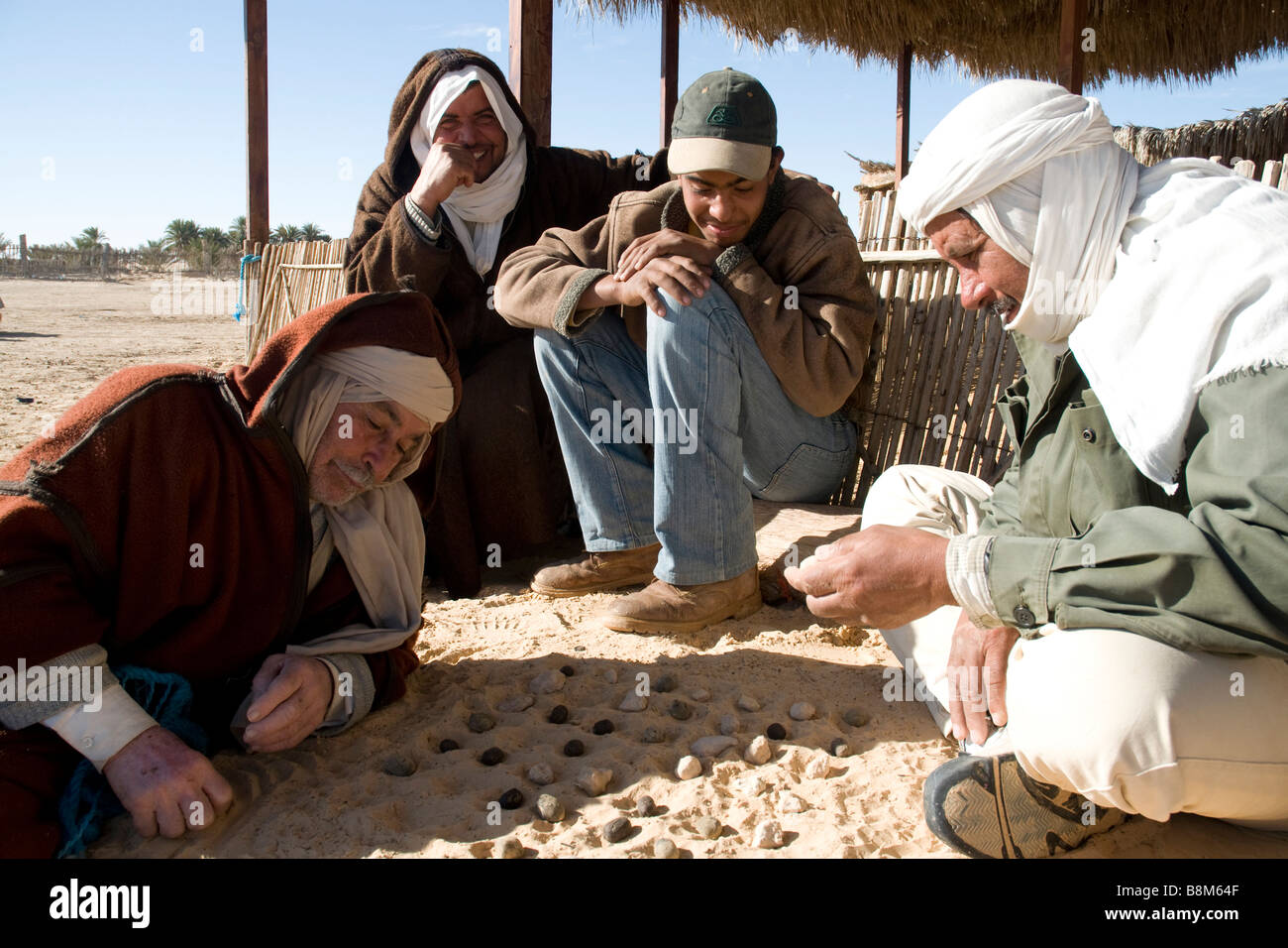 Waiting for tourists in Douz, Tunisia, Berber camel owners play a chess ...