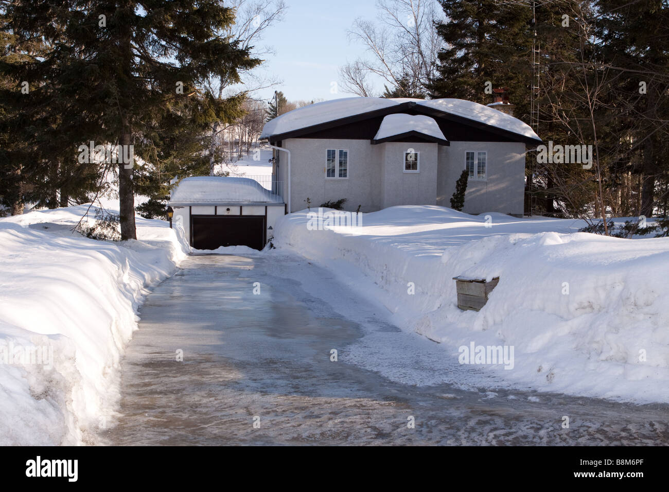country cottage by a lake in winter with icy driveway Stock Photo - Alamy