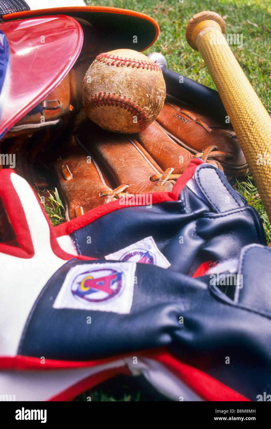 Collection of baseball gear on grass ball bat glove cap hat batting ...