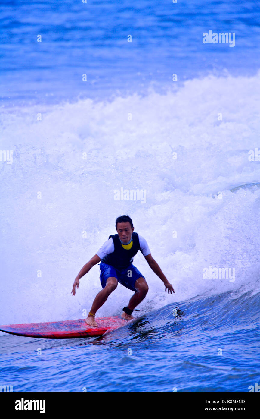 Man surfing on the sea skillfully with huge surf behind Stock Photo - Alamy