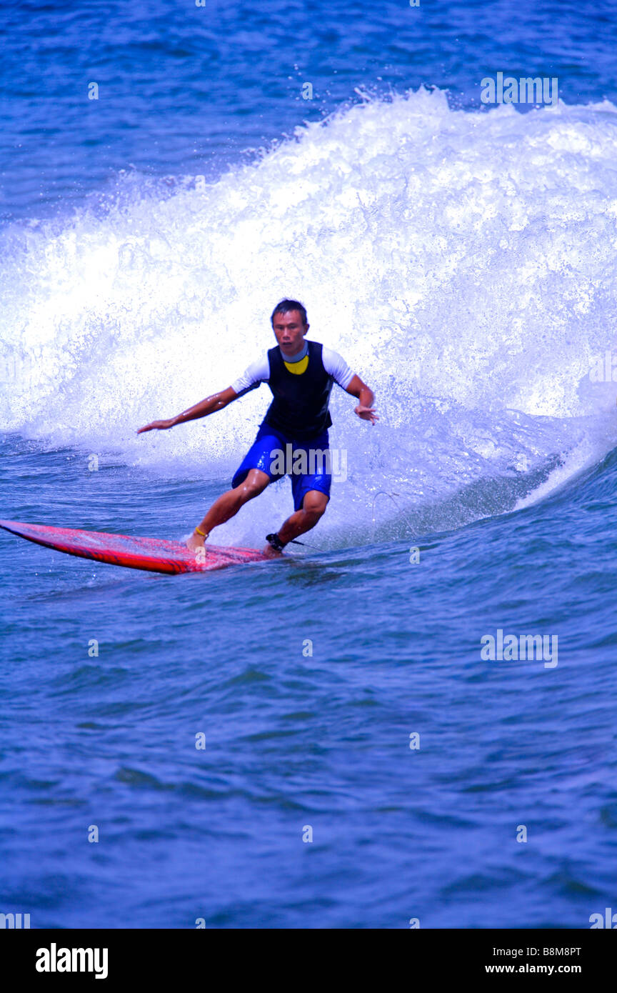 Man surfing on the sea skillfully with huge surf behind Stock Photo - Alamy