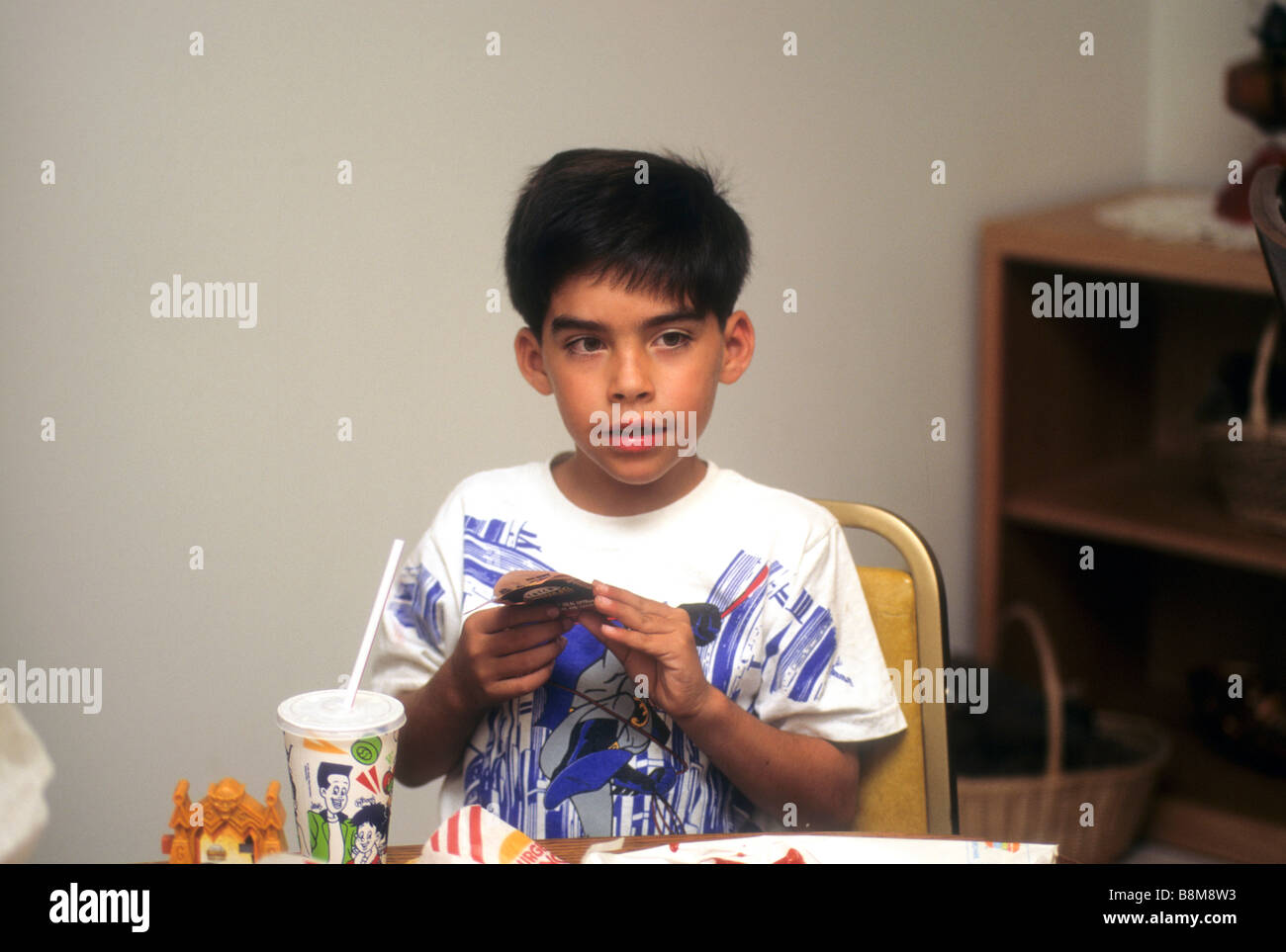 Hispanic boy eats snack at fast food restaurant Stock Photo - Alamy