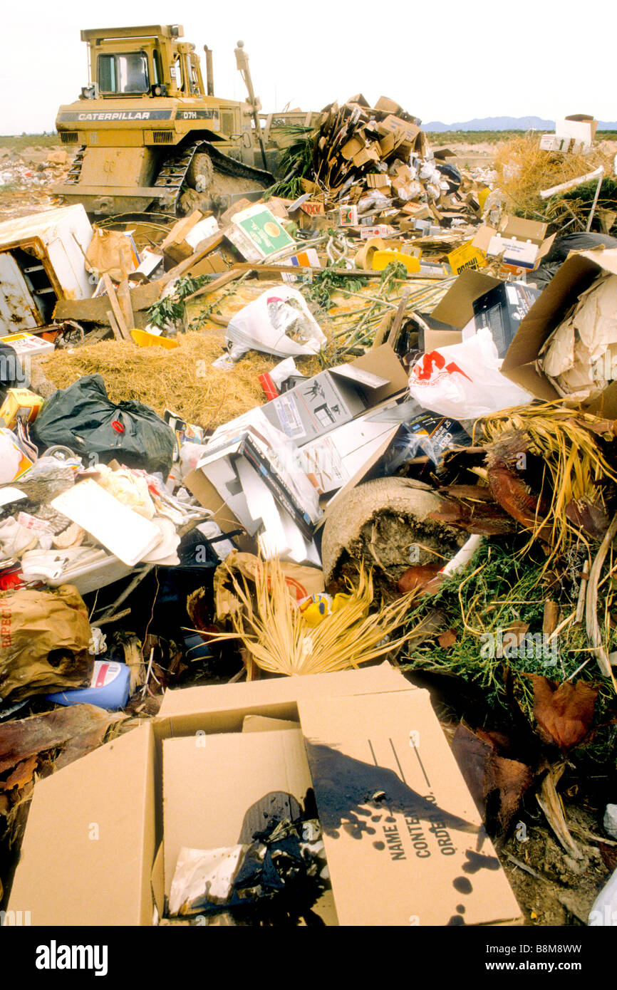 Bulldozer tractor moves mounds of trash in landfill dump site Stock ...