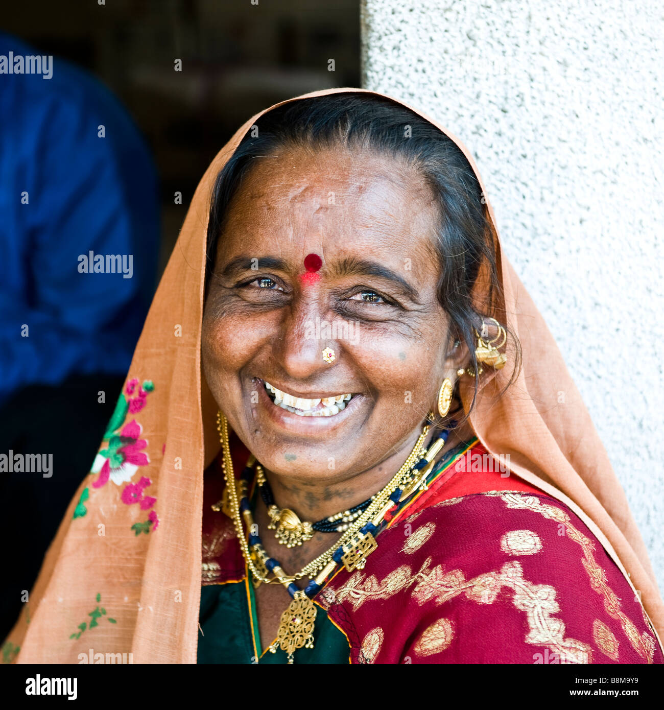 Portrait of a senior Indian lady seated outside a shop feeling happy ...