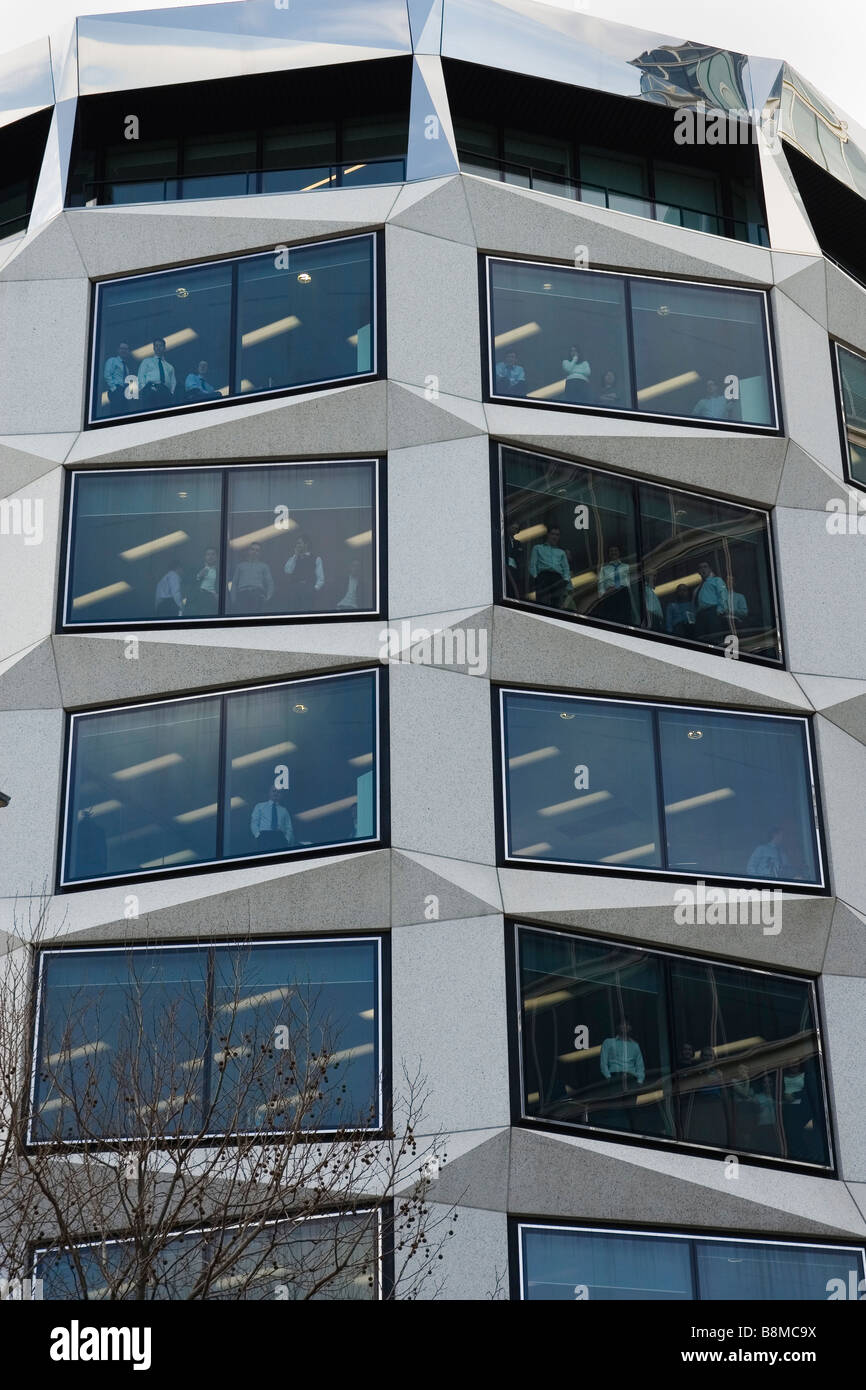 office workers standing by windows gazing outside in City of London ...