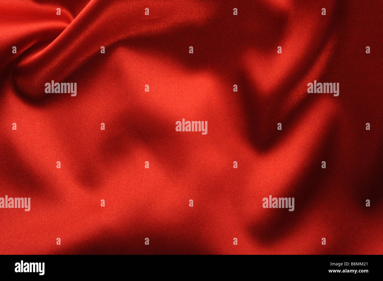 red satin background A satiny fabric with beautiful light shadow waves ...
