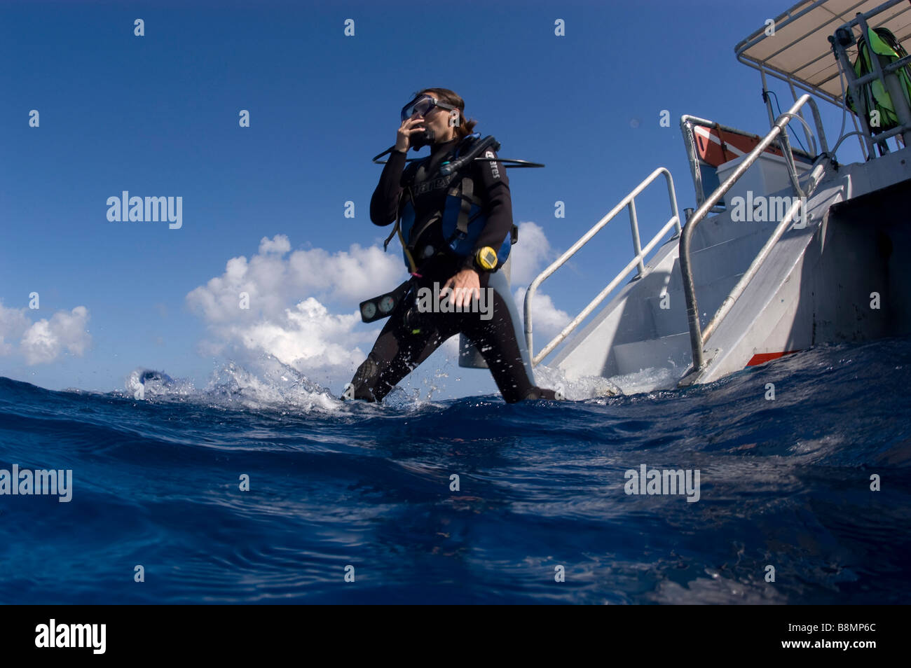 A scuba diver takes a giant stride entry into the ocean at the start of ...