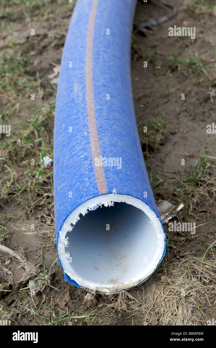 A blue pipe lies discarded on a construction site Stock Photo - Alamy