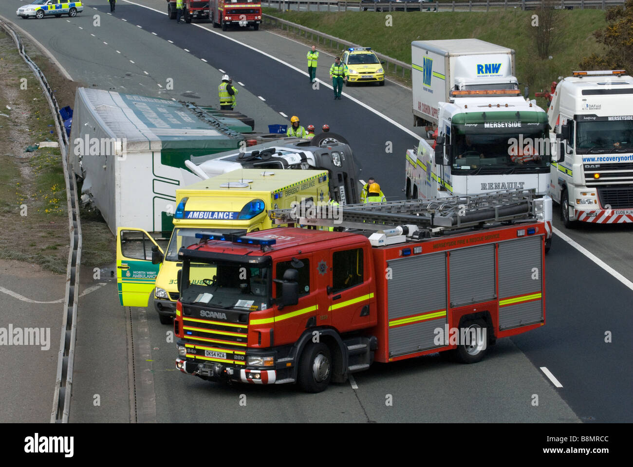 HGV lorry overturned on motorway with ambulance and fire service Stock ...