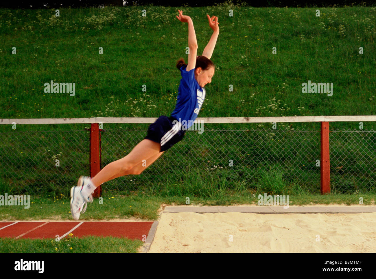 A girl practises the long jump during athletics training Stock Photo ...