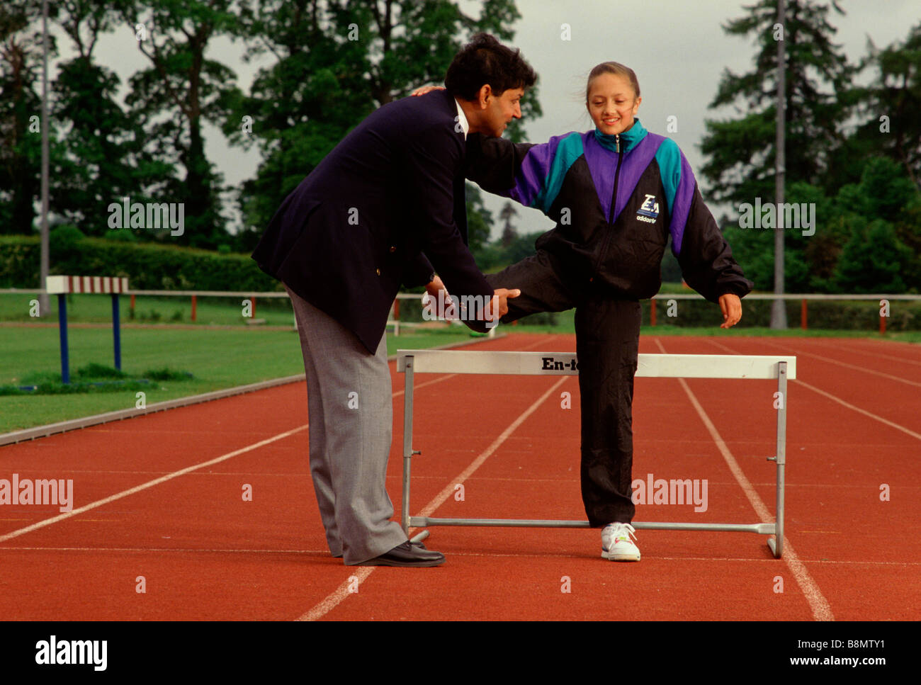 A young athlete receives hurdles instruction Stock Photo - Alamy