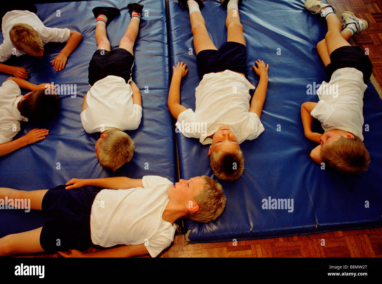 Schoolchildren lie on a gym mat Stock Photo - Alamy