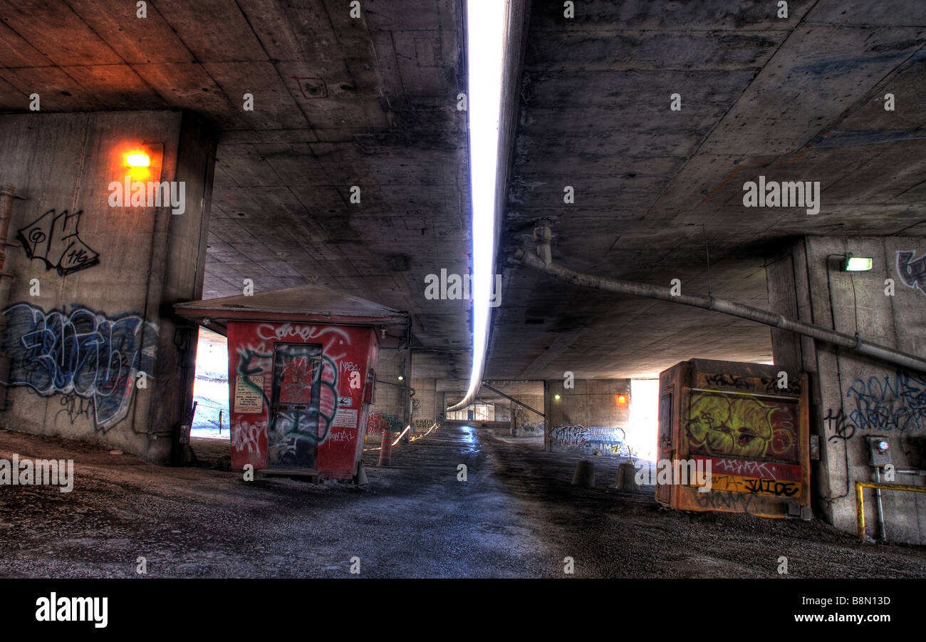 Color photograph of graffiti in an urban underpass parking lot, eerie ...