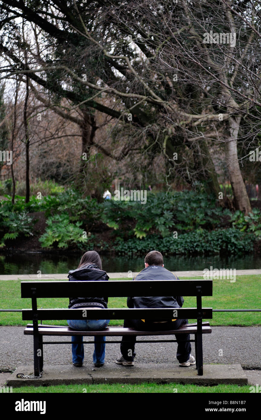 Man and woman couple sitting on a Bench face look looking facing st ...