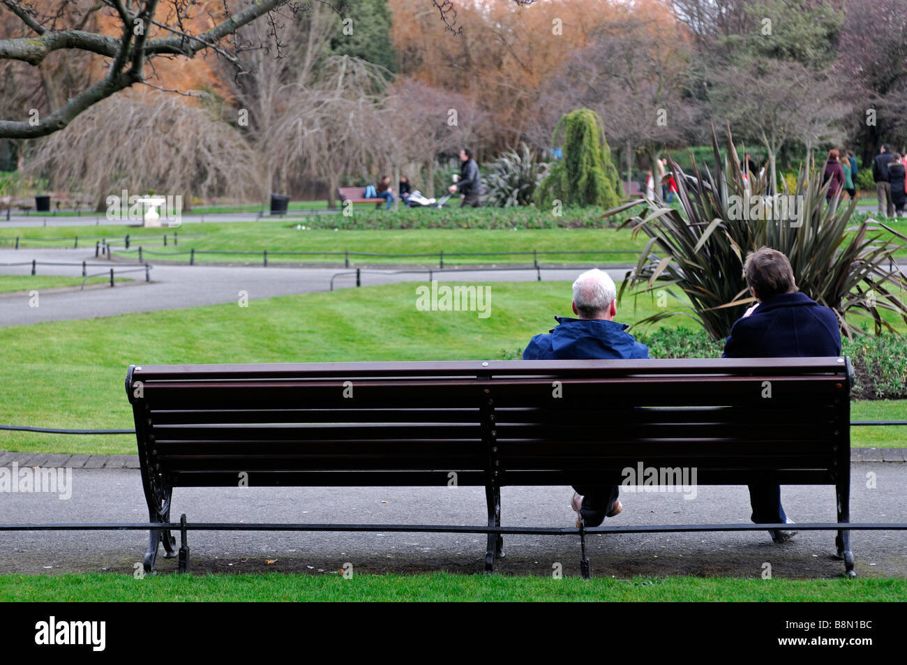 Man and woman couple sitting on a Bench face look looking facing st ...