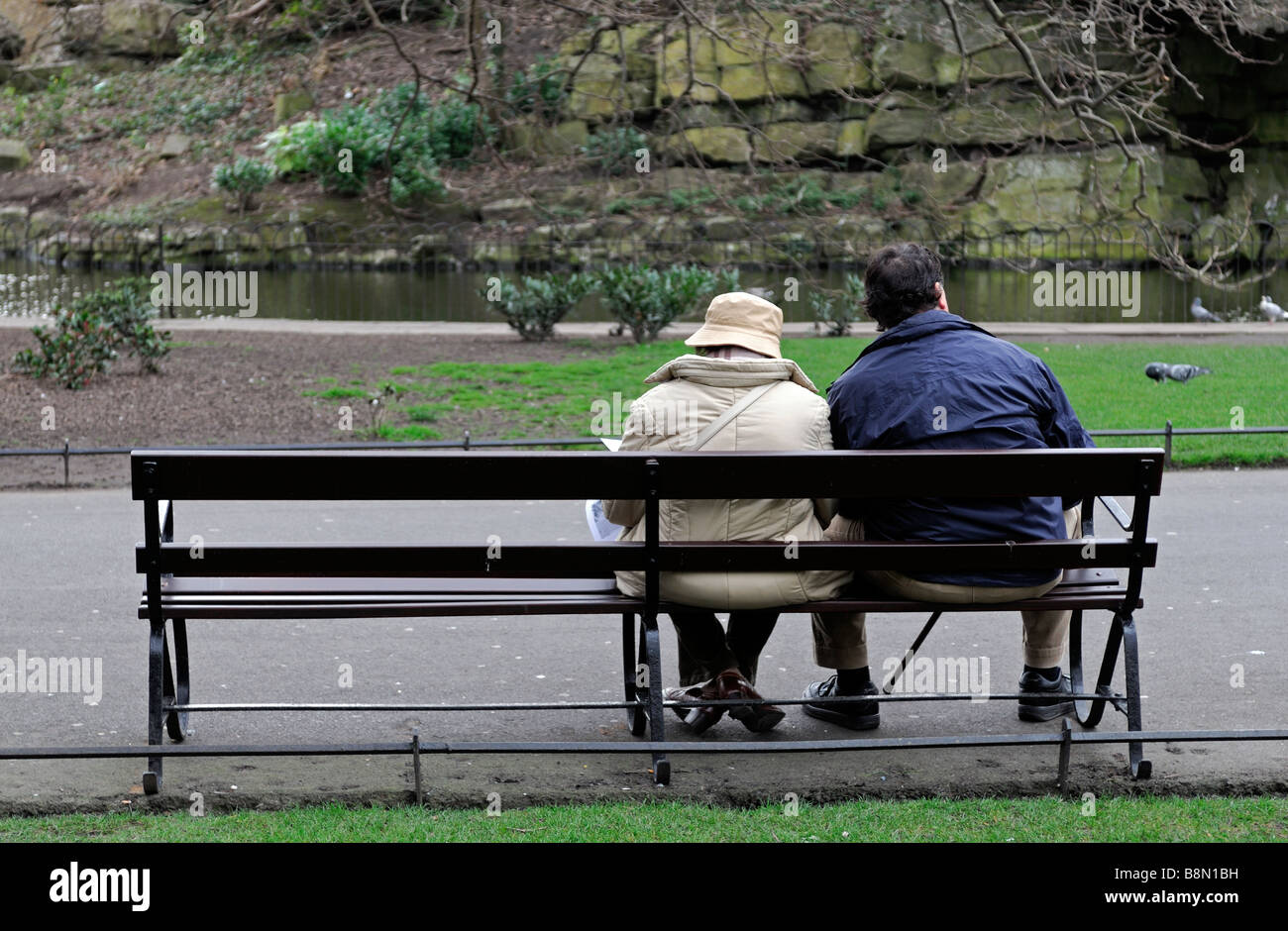 Man and woman couple sitting on a Bench face look looking facing st ...