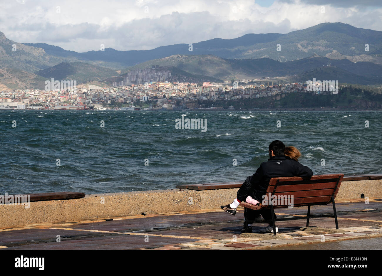 Man and woman couple sitting on a Bench face look looking facing the ...