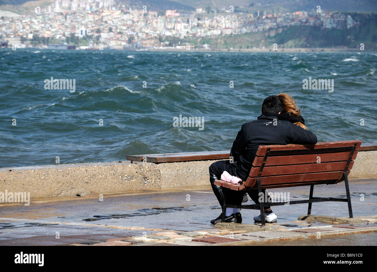 Man and woman couple sitting on a Bench face look looking facing the ...