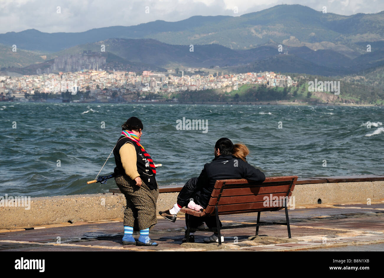 People sitting on bench Stormy weather aegean sea and gulf of izmir ...