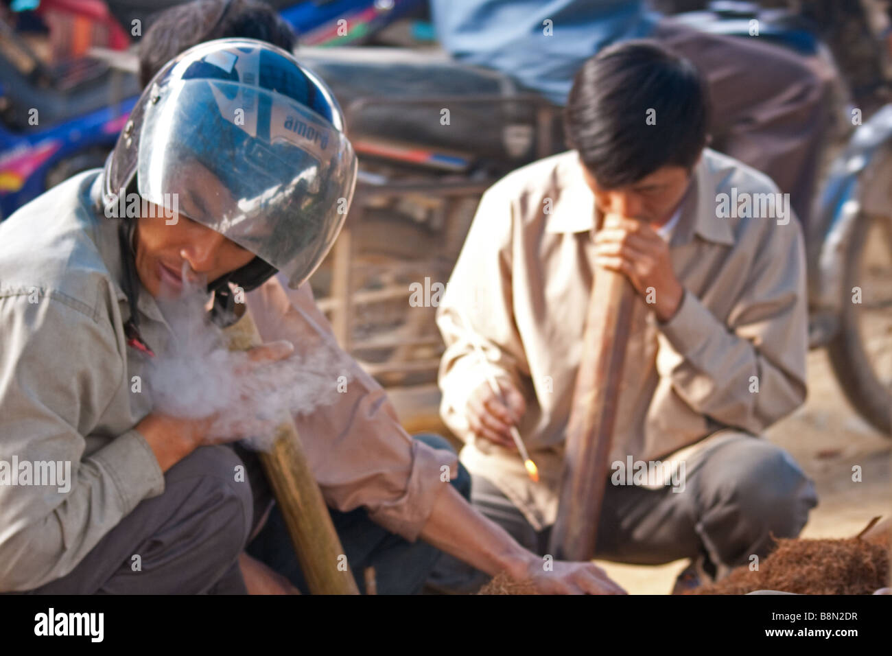 Vietnamese enjoy smoking a traditional water pipe with a free tester of ...