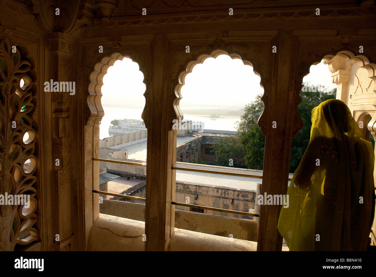 indian woman in traditional dress at a balcony window at the city ...