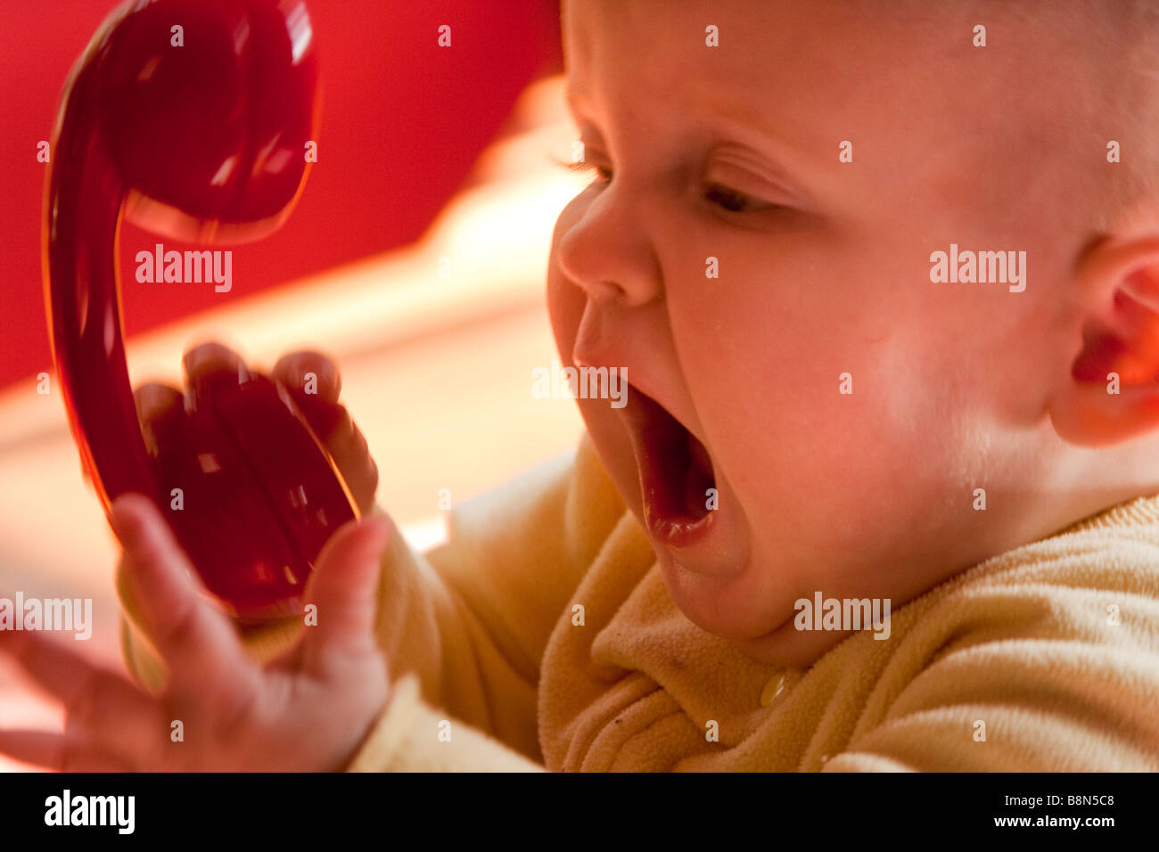 An infant girl screams at a play phone Stock Photo - Alamy