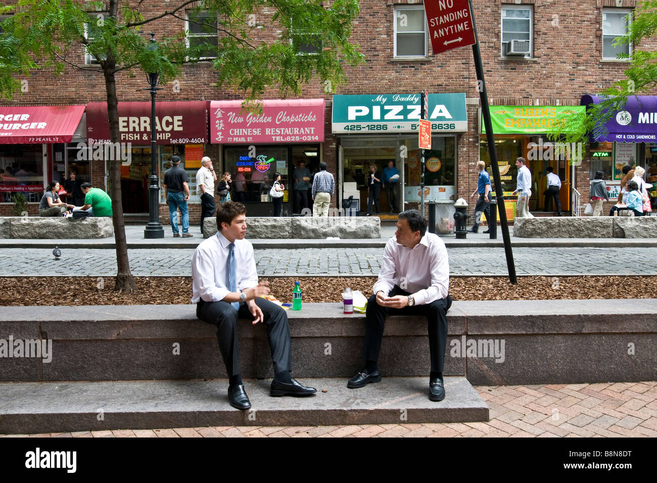 Street scene with several downtown office workers sitting outside ...
