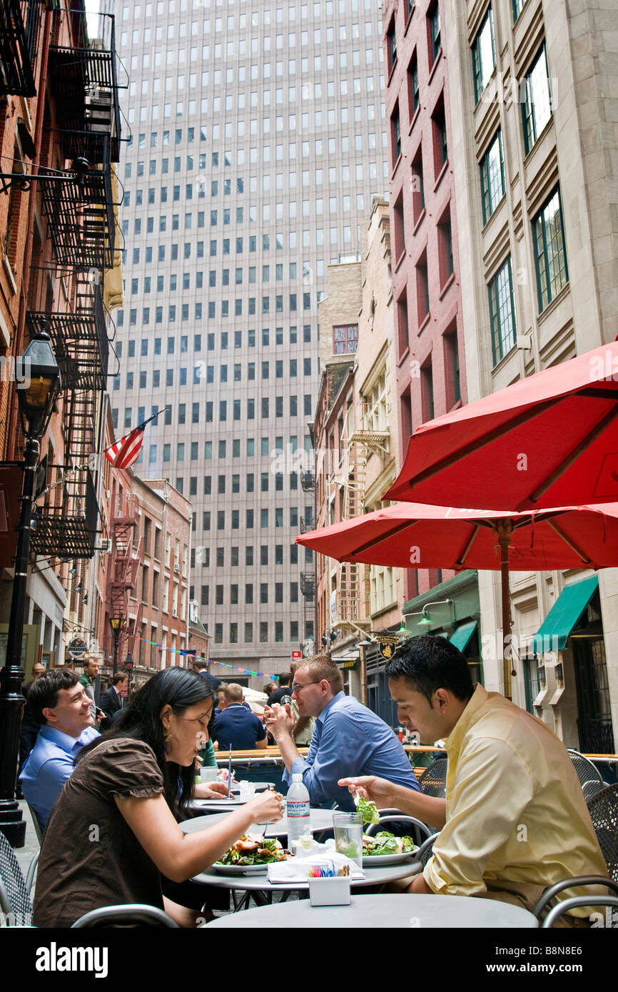 Street scene with people having lunch at a casual outdoor restaurant ...