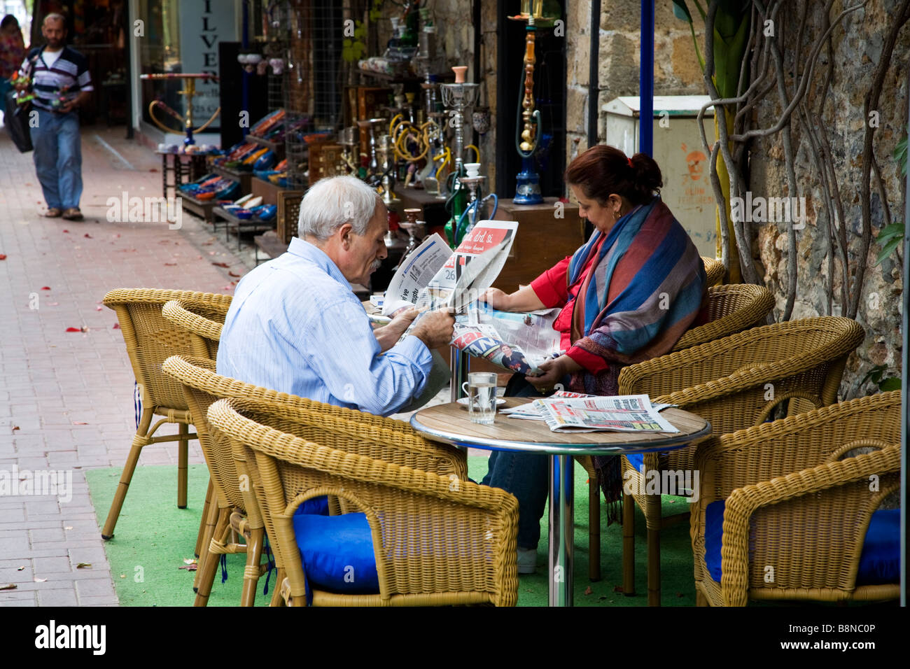 A Turkish couple reading newspapers at a pavement cafe in Fethiye ...