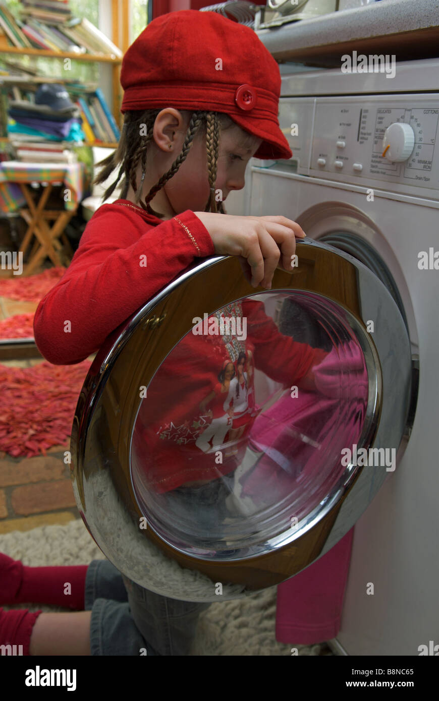 Young girl loading her clothes into a washing machine Stock Photo - Alamy
