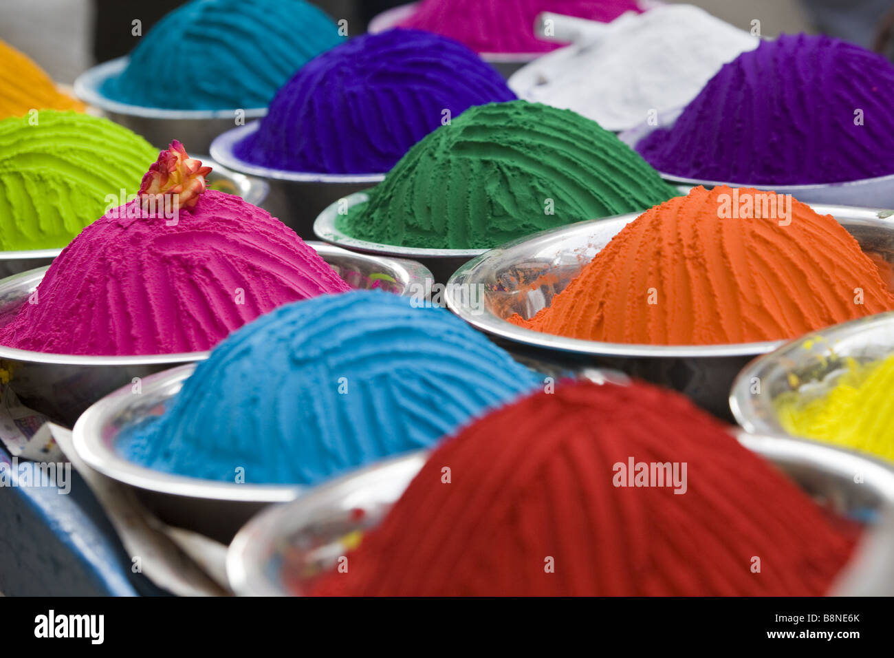 Metal containers filled with coloured Indian rice powder used for ...