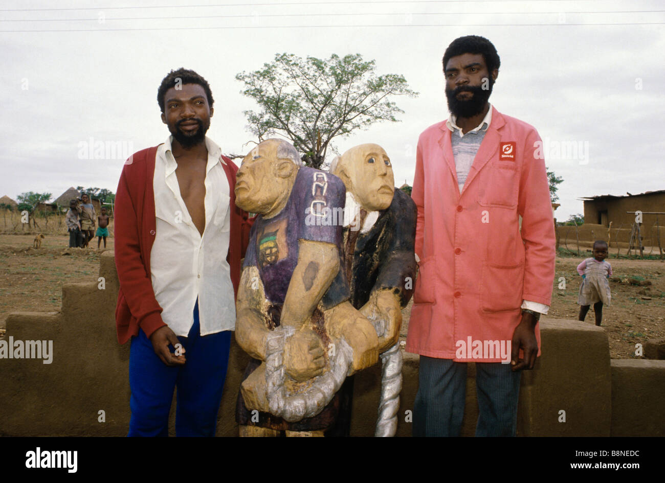 African artists, the Ndou brothers stand next to their carving of ...