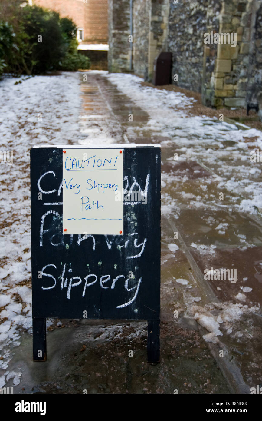 Sign says caution slippery path Stock Photo - Alamy