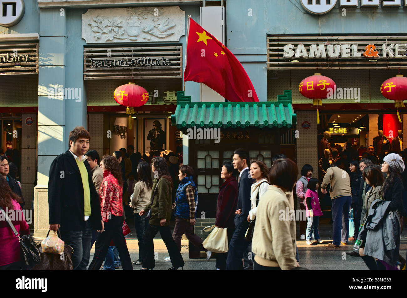 Shoppers pass by communist Chinese flag Guangzhou China Stock Photo - Alamy