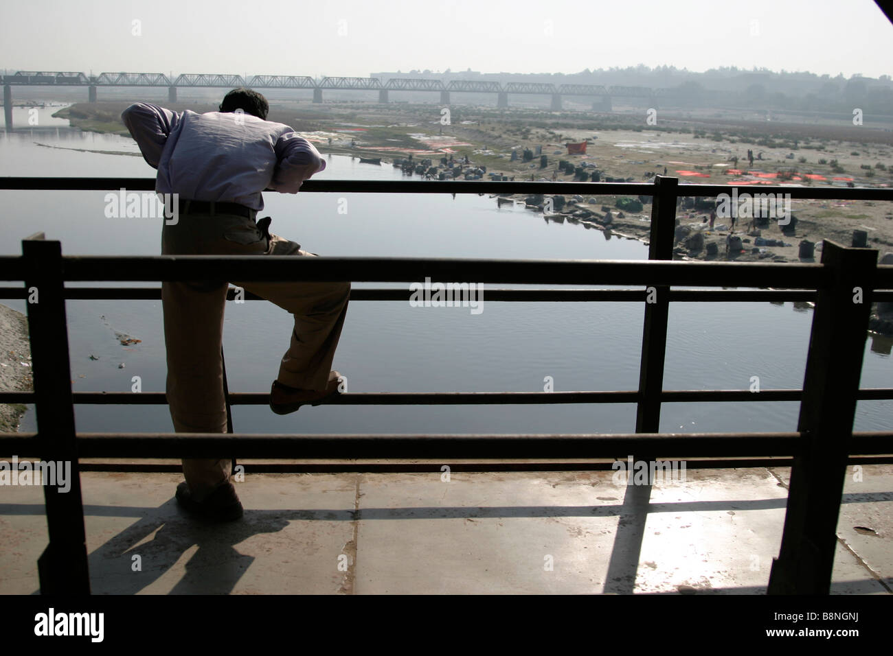 Man looks at river from a bridge in India Stock Photo - Alamy