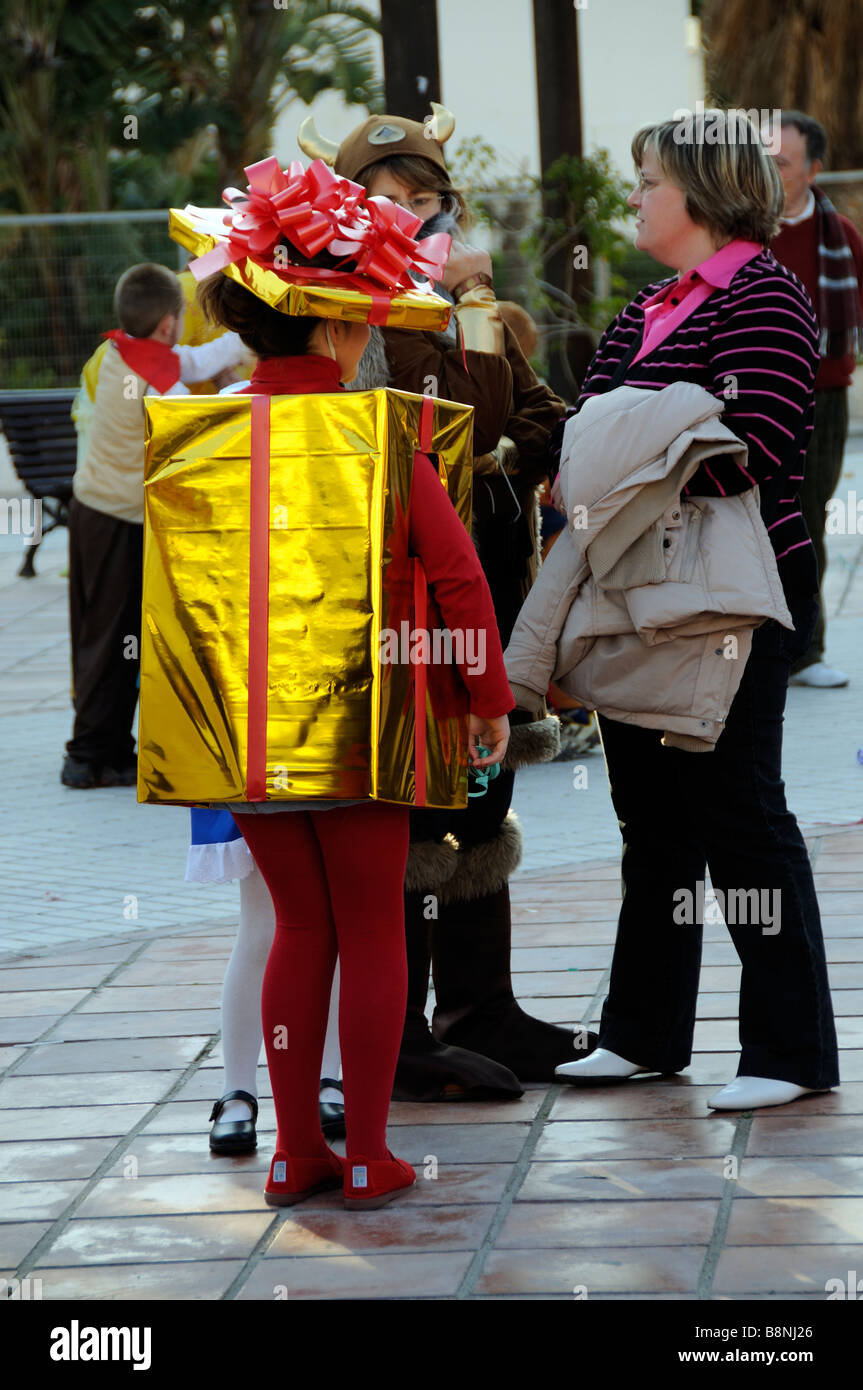 Little girl in fancy dress as a gold package present wrapped in red ...