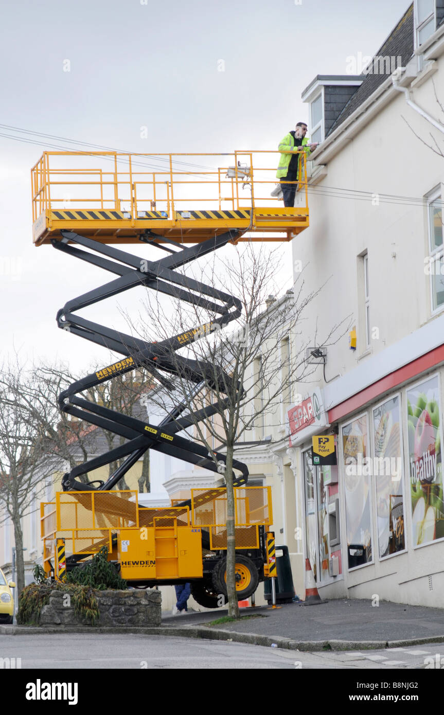 A man repairs a window on an extendable platform Stock Photo - Alamy