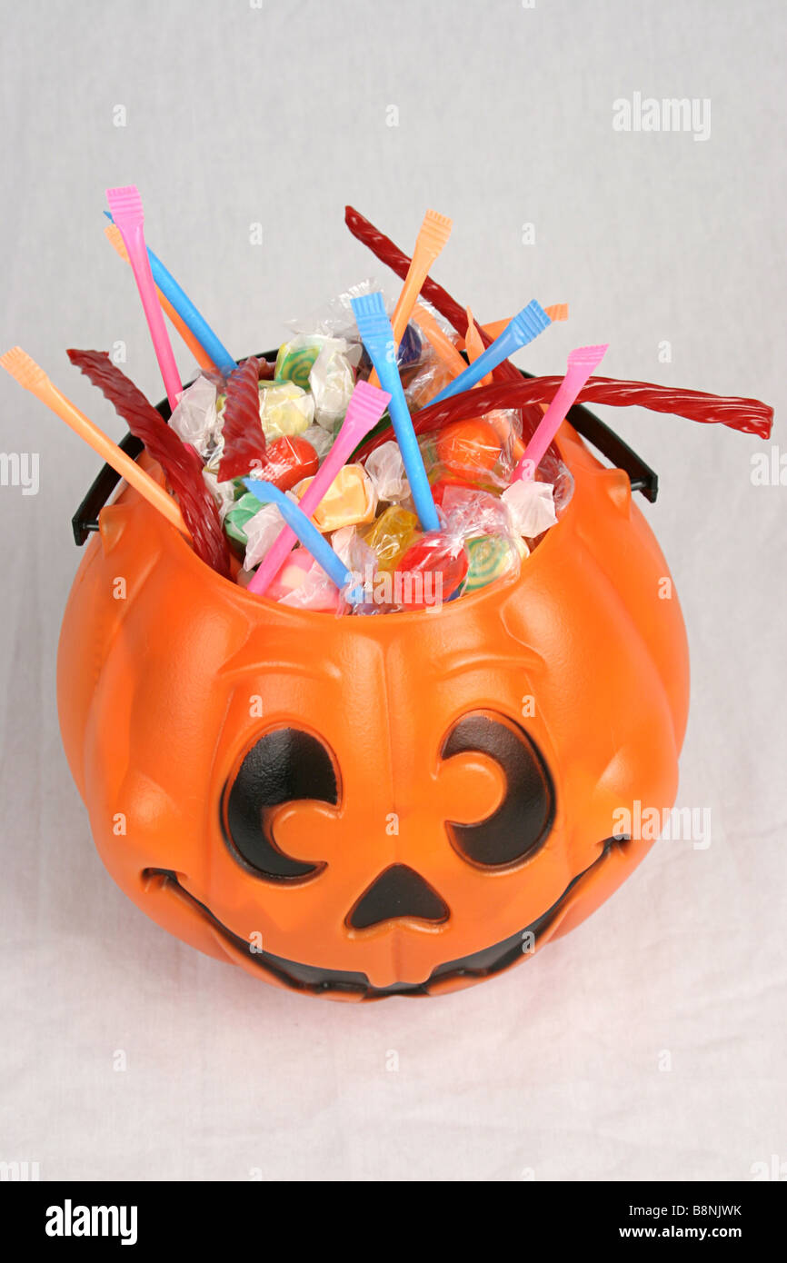 Halloween pumpkin bucket filled with candy Stock Photo - Alamy
