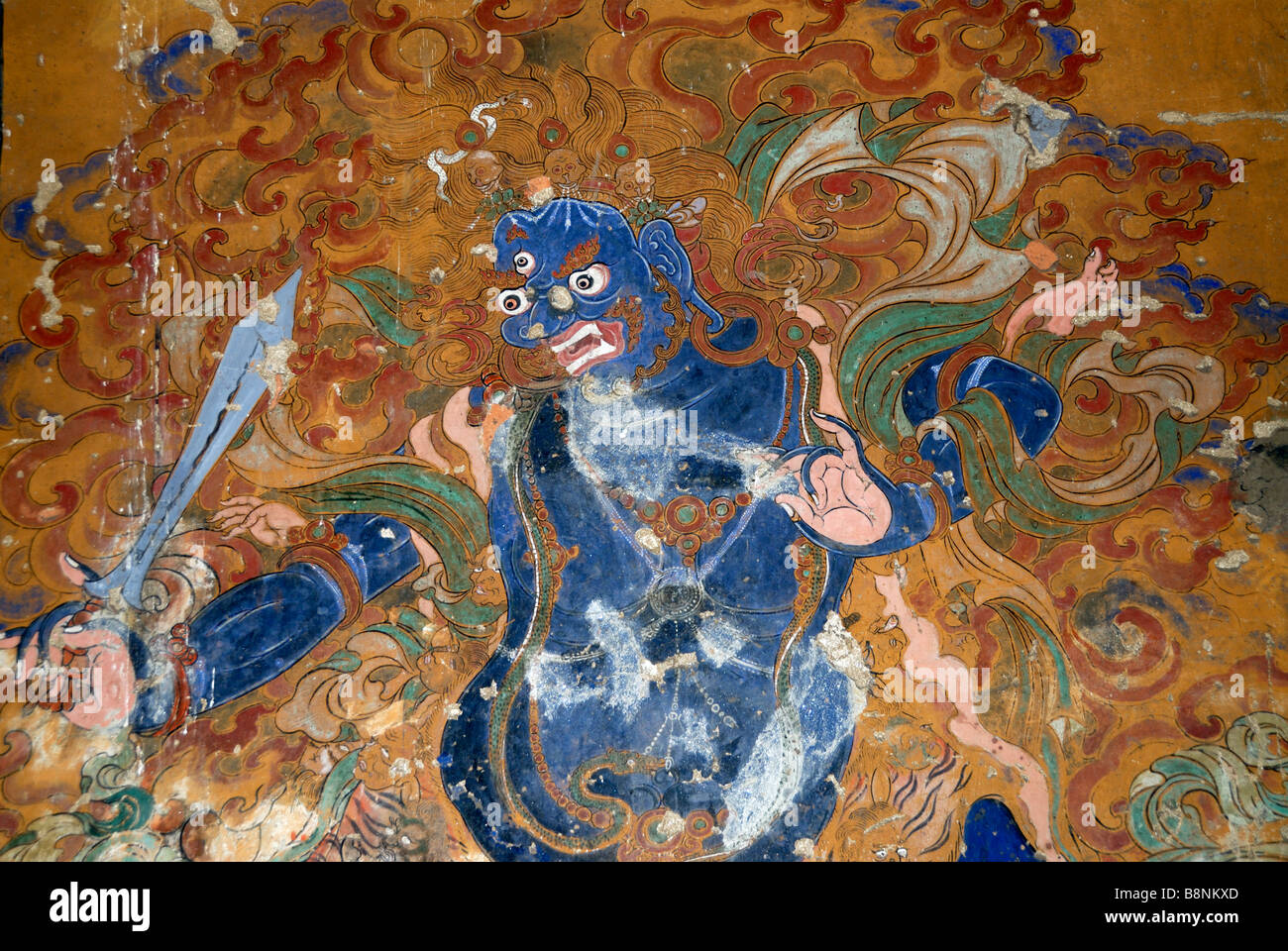 Ancient mural painting of a blue three-eyed demon. The demon has ...