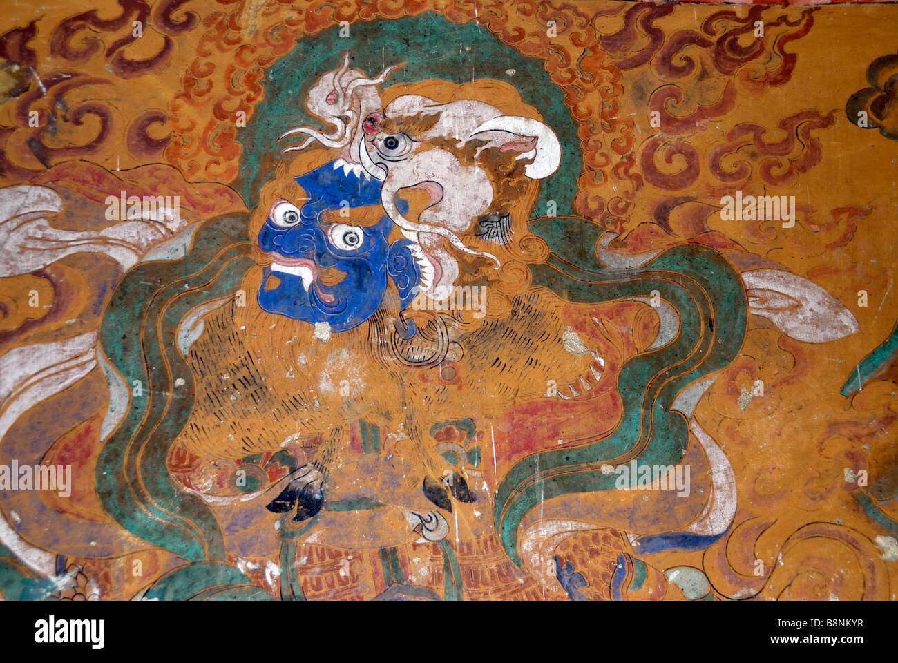 Ancient mural painting of a blue faced demon. The demon has a makara, a ...