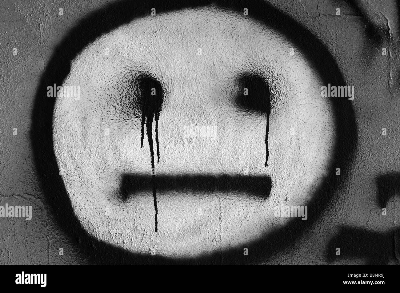 Graffiti smiley happy face on cement wall, vandalism, menacing eyes ...