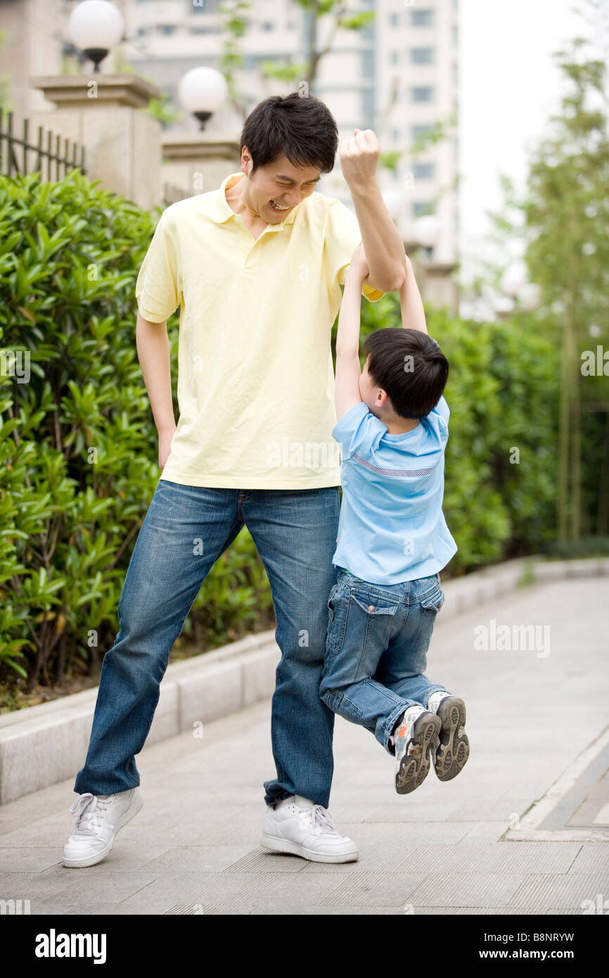 Father lifting son by his arm Stock Photo - Alamy