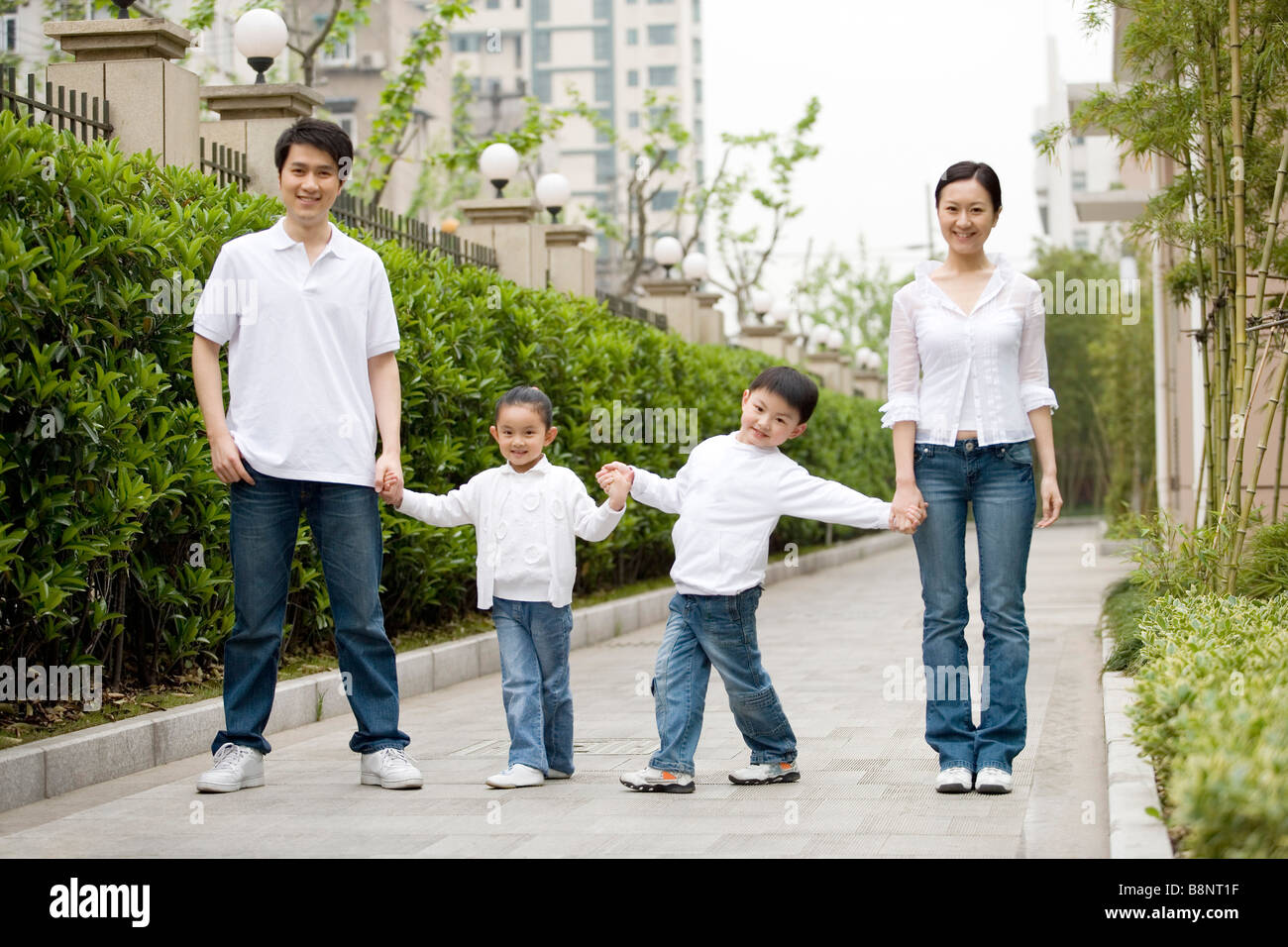 Parents and children walking in park smiling portrait Stock Photo - Alamy